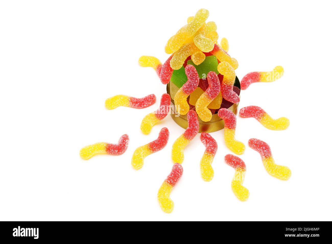 Large pile of jelly candies and gummy worms in a small round tin box ...