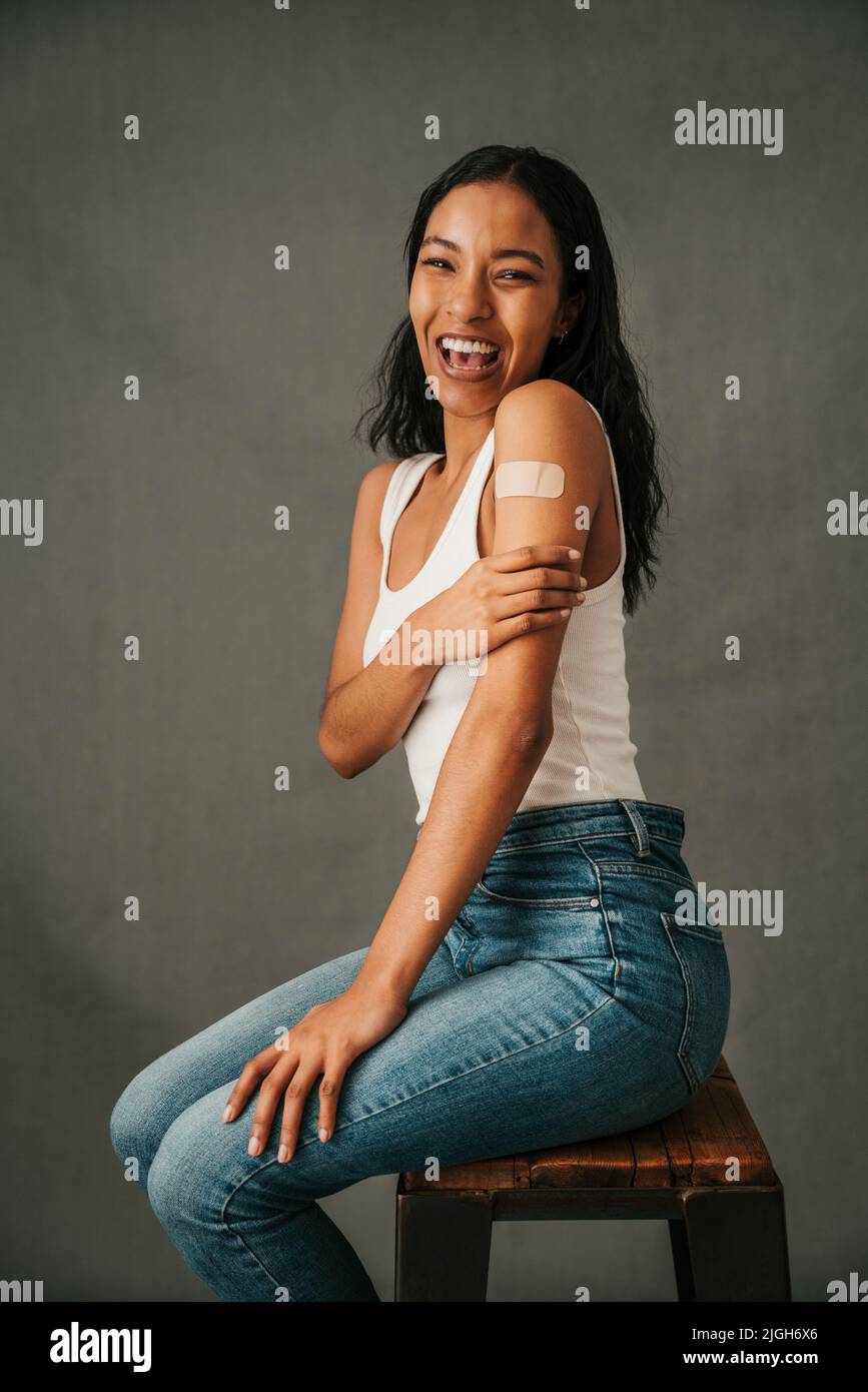 Laughing African American female touching her arm Stock Photo - Alamy