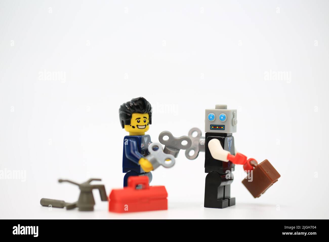 Man help to wind up the clockwork robot Stock Photo - Alamy