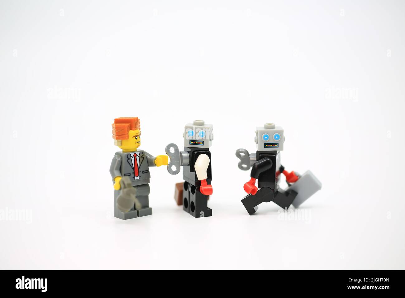 Man help to wind up the clockwork robot Stock Photo - Alamy