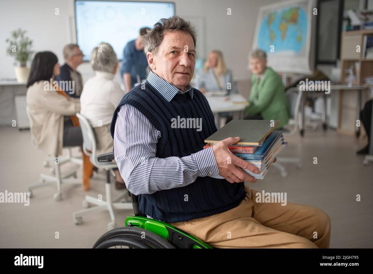 Happy disabled man senior student on wheelchair holding books and ...