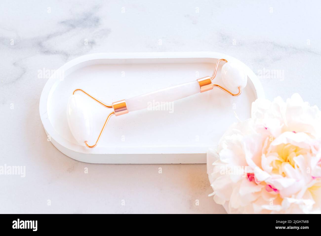 Pink Guasha massage tools in concrete tray on marble background with ...