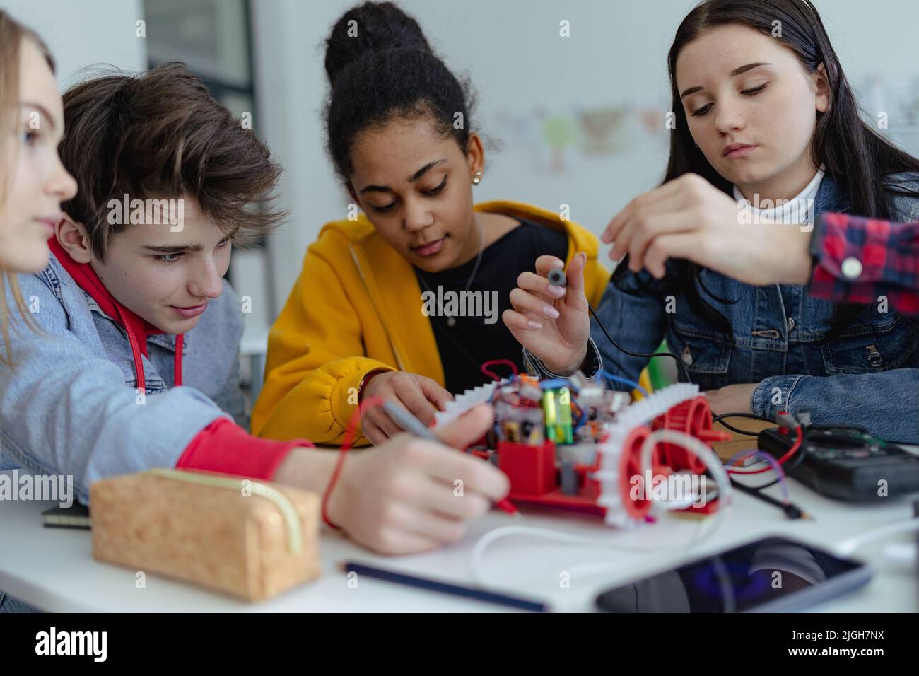 Group of high school students building and programming electric toys ...
