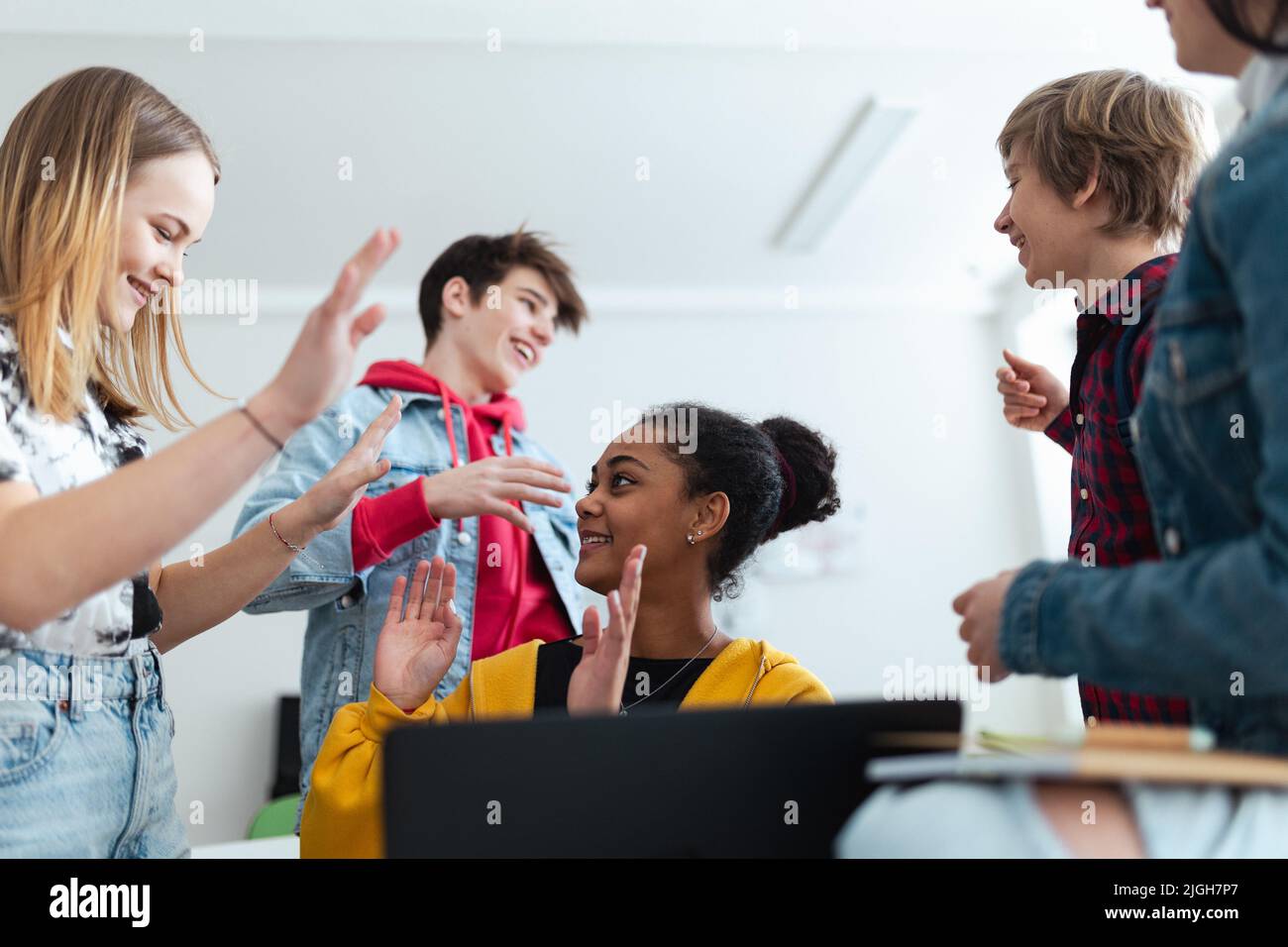 High school students meeting and greeting in classroom after school ...