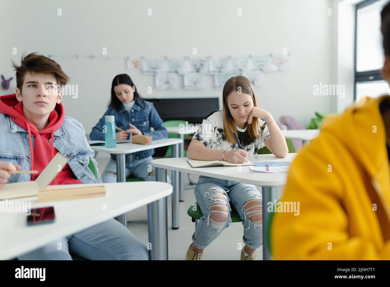 High school students paying attention in class, sitting in their desks ...