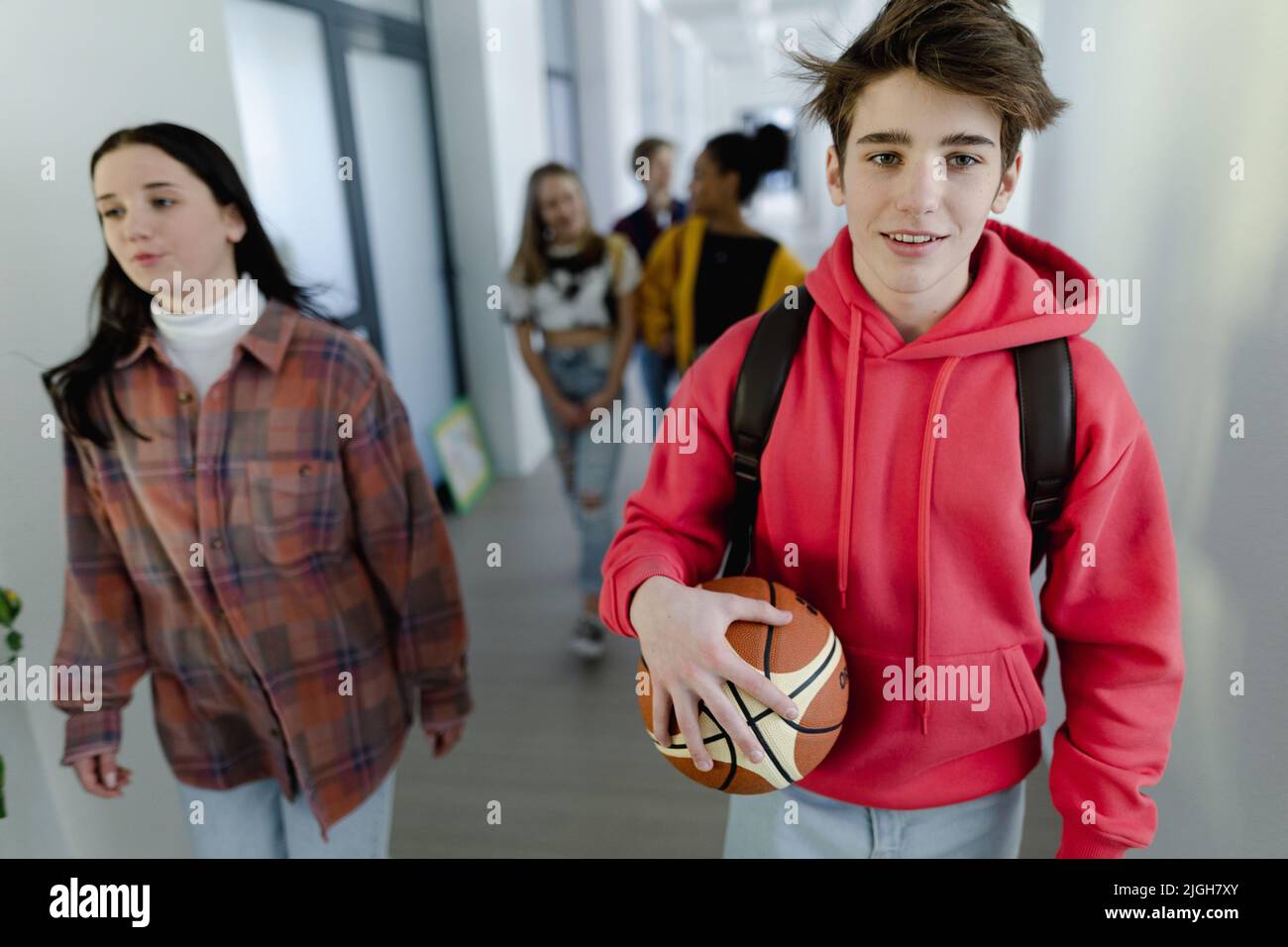Young high school students walking in corridor at school, back to ...