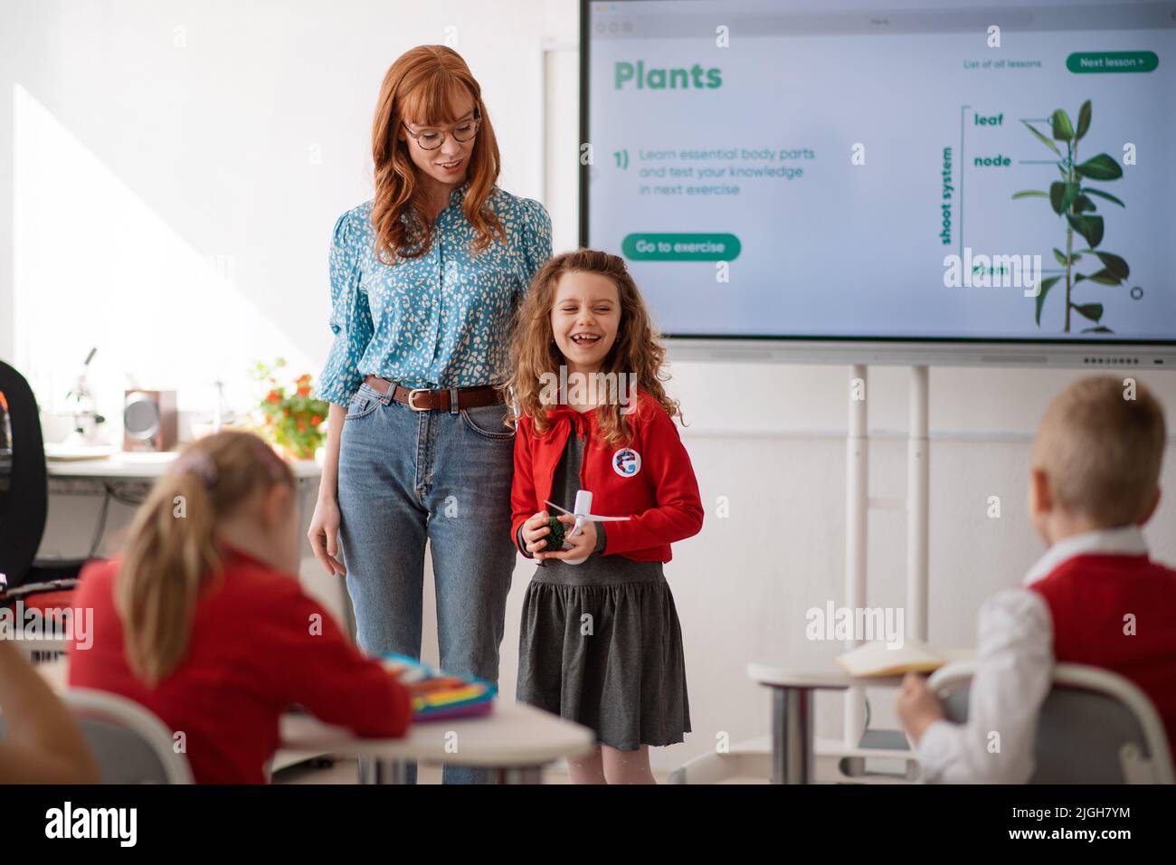 Teacher listening schoolgirl in classroom, science lesson Stock Photo ...