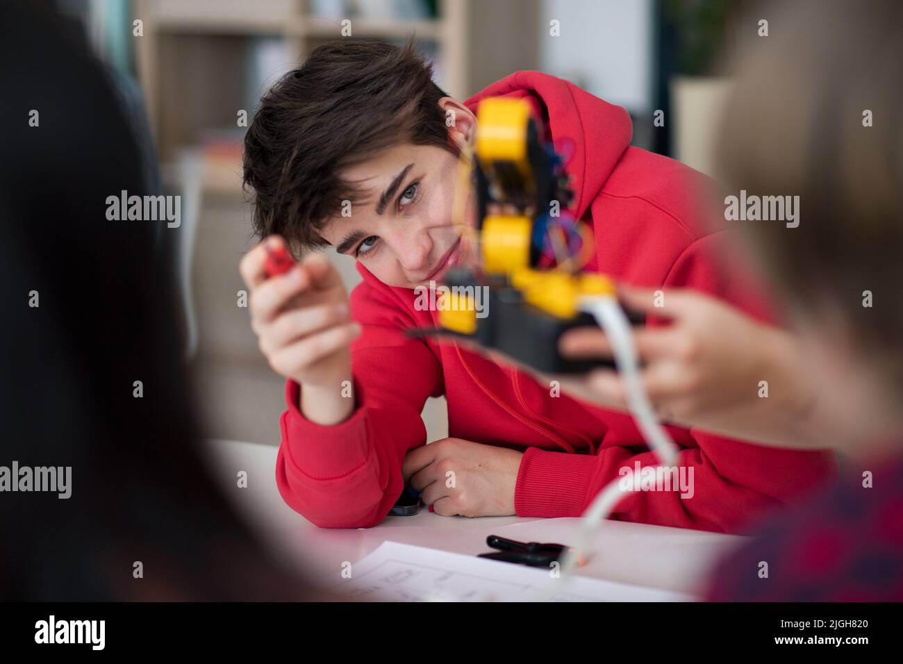 Group of students building and programming electric toys and robots at ...