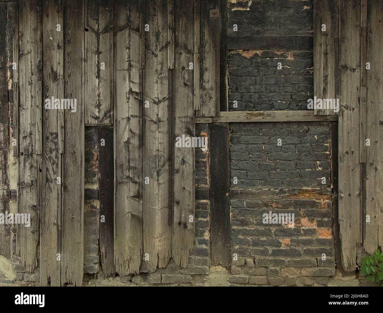 A stone wall covered with rotten broken wood Stock Photo - Alamy