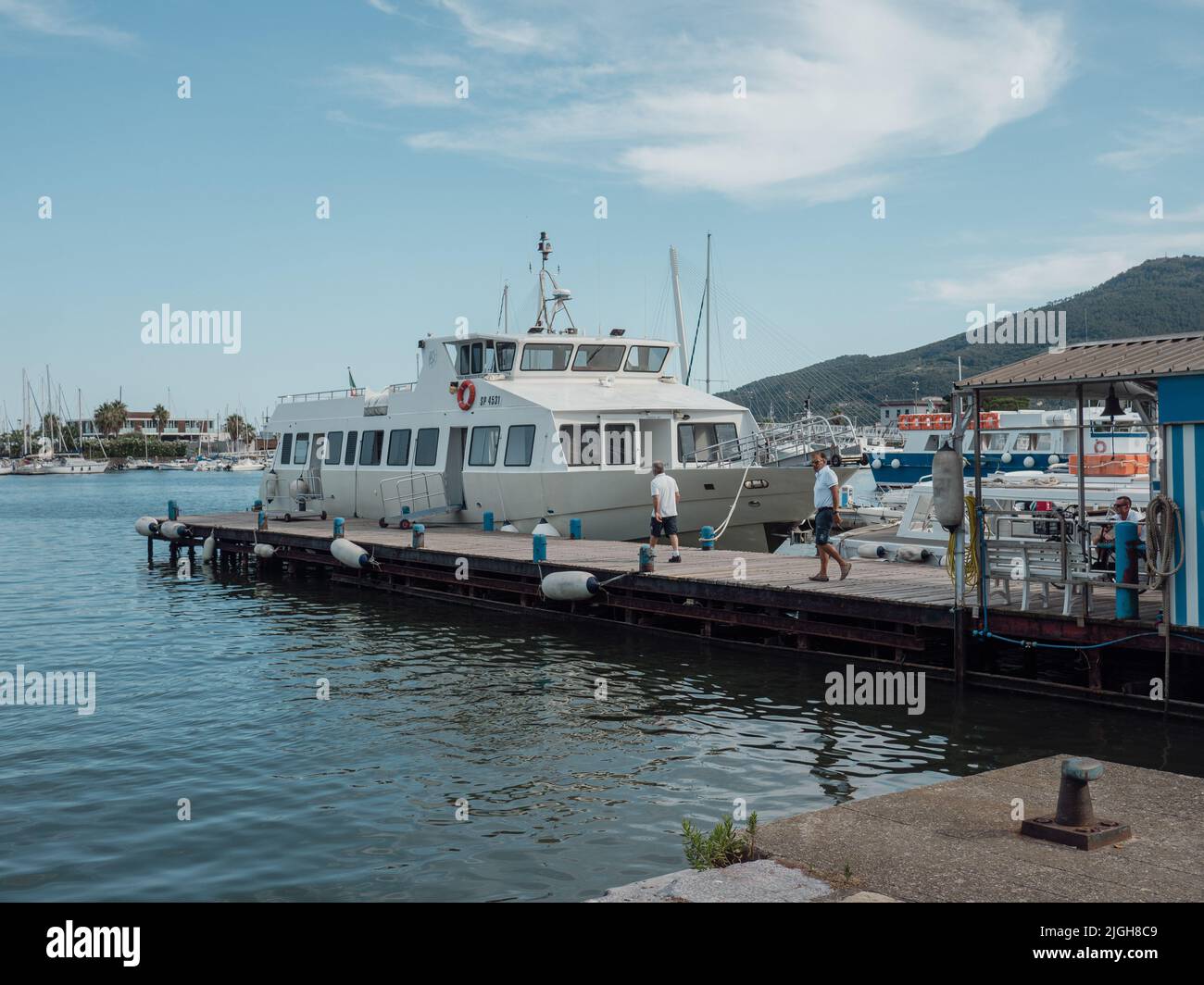 People walking near the sea and boats Stock Photo - Alamy