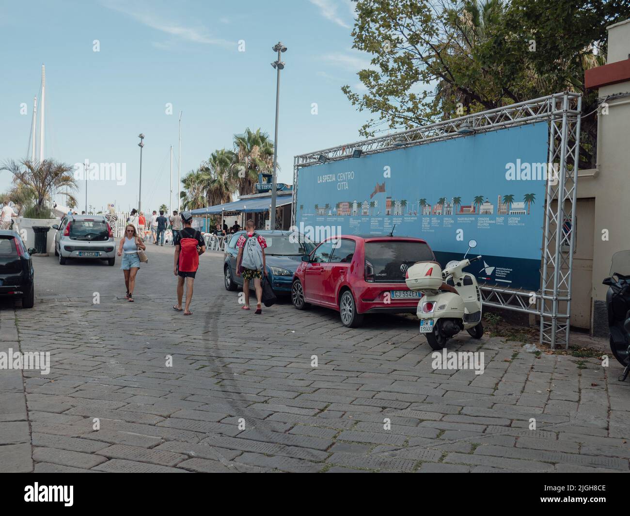People walking near the sea and boats Stock Photo - Alamy