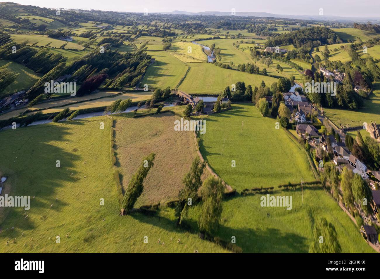 A bird's eye view of houses surrounded by green cultivated fields in a countryside Stock Photo ...