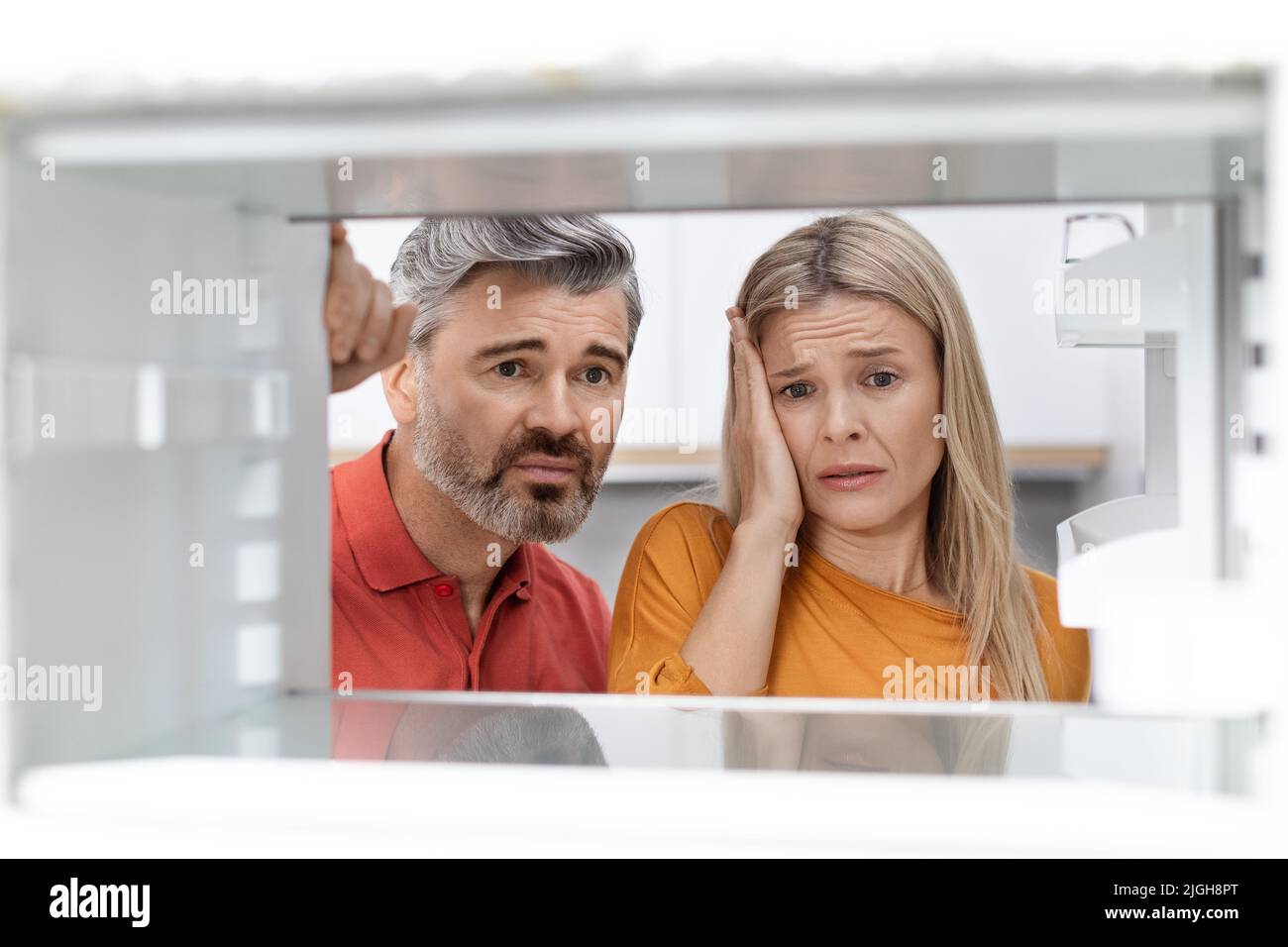 Upset couple looking inside empty fridge at home, closeup Stock Photo ...
