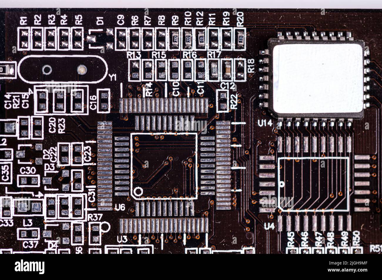 macro close-up shot of microchip on black printed circuit board, computer vide ocard with ...