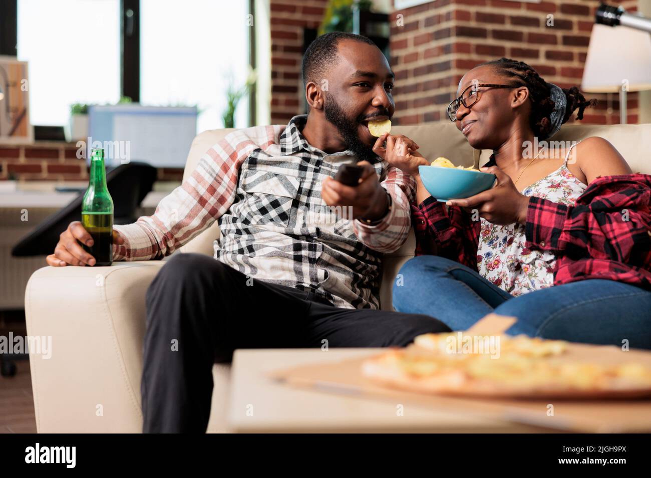 Happy girlfriend and boyfriend having fun with snacks and movie on tv ...