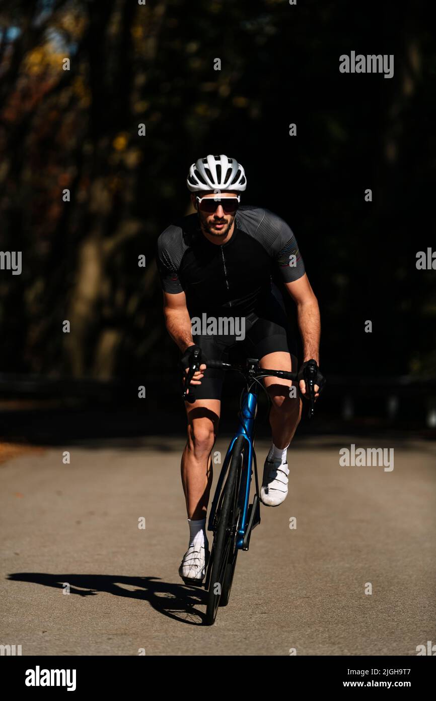 A vertical shot of a professional male cyclist with sunglasses on a ...
