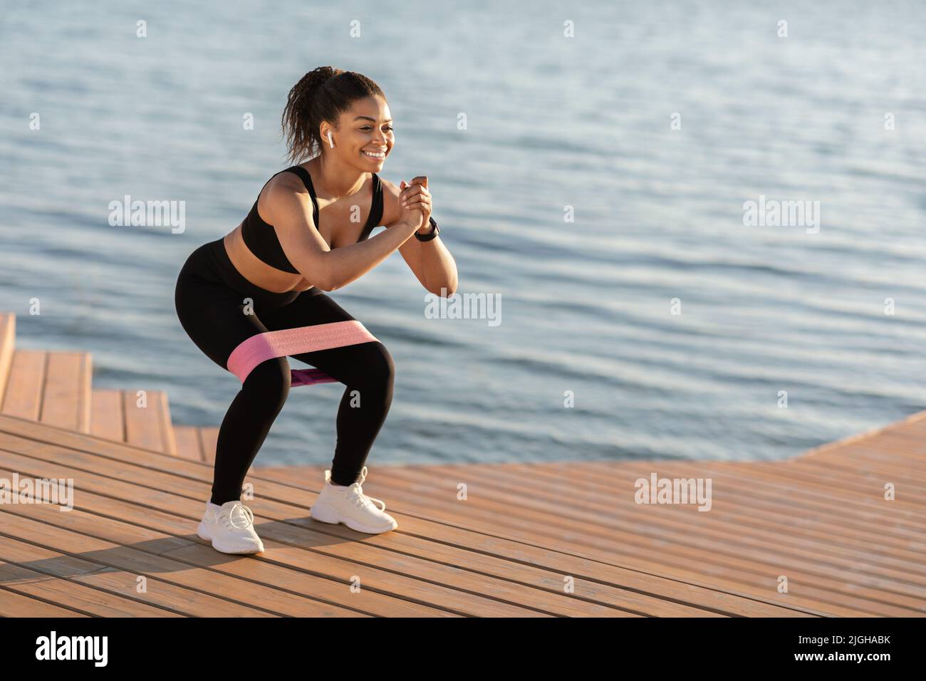 Athletic young black woman doing workout outdoors, using band Stock ...