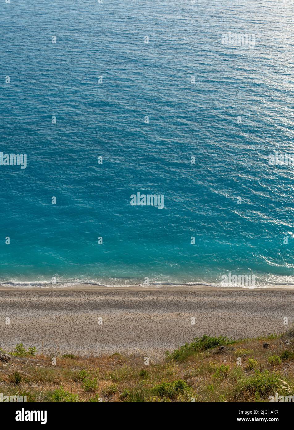 Beautiful wild Mediterranean pebble beach under a large massive cliff ...