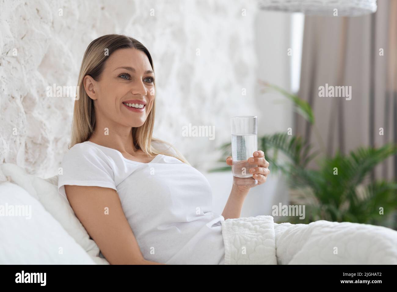 Healthy young woman drinking fresh water after waking up Stock Photo - Alamy