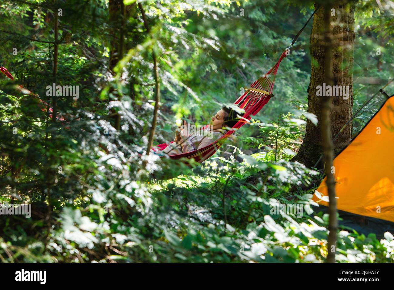 woman laying down in hammock reading book copy space Stock Photo - Alamy