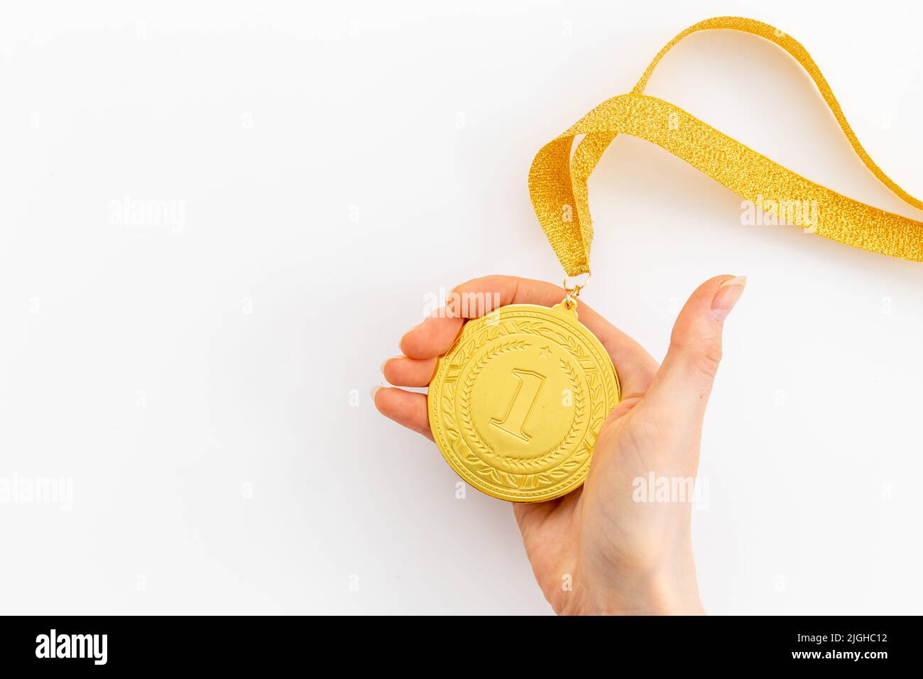Hand holding up gold medal first place. Winner concept Stock Photo - Alamy