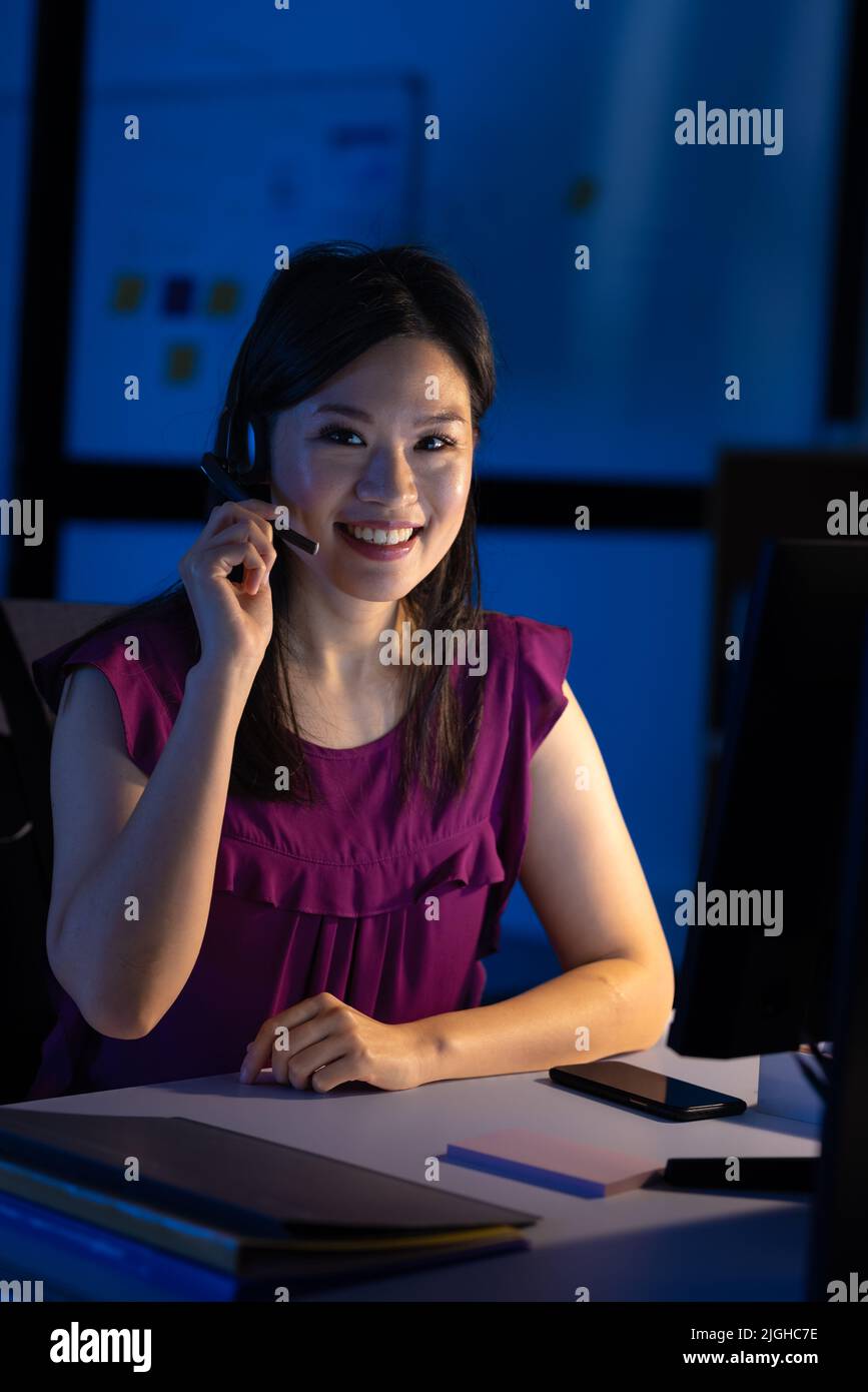 Portrait of smiling asian female customer representative talking with ...
