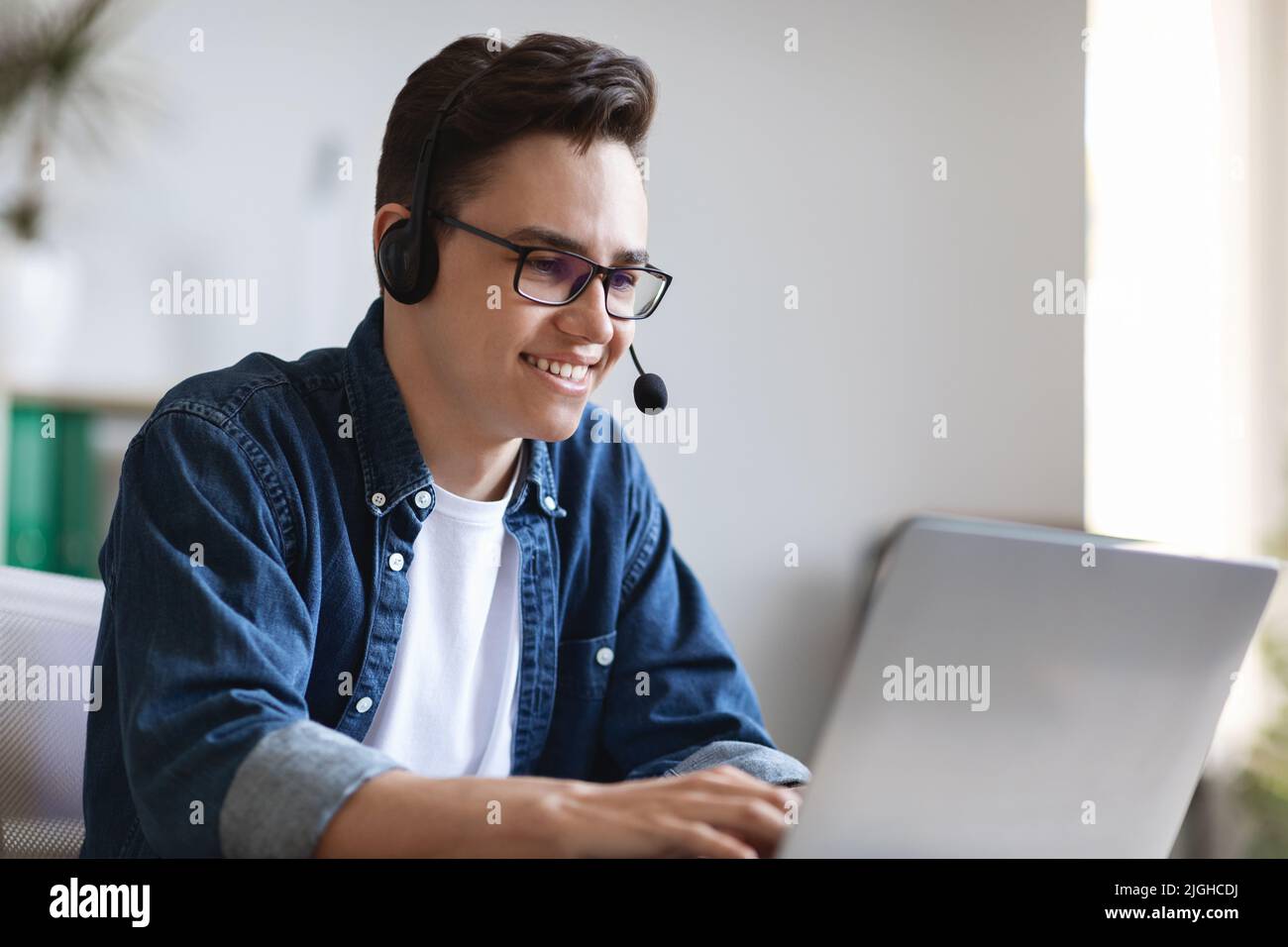 Hotline Concept. Smiling Call Center Operator In Headset Working With Laptop Stock Photo - Alamy