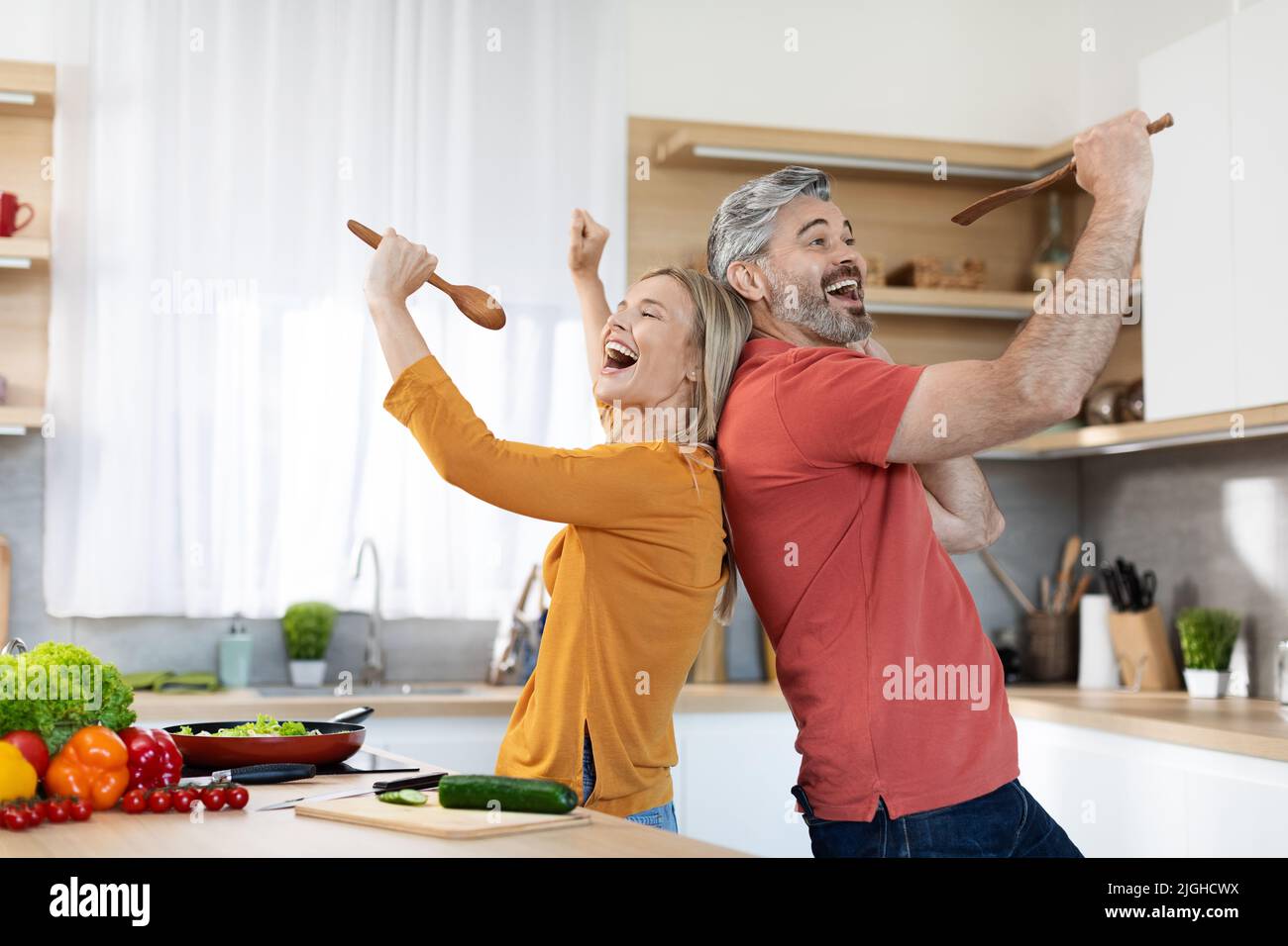 Happy husband and wife having fun while cooking at home Stock Photo - Alamy