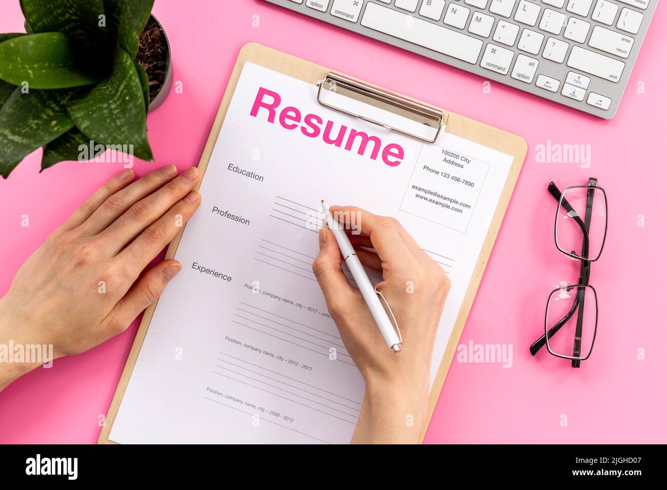 Hands with resume application form on office table. Find new job ...