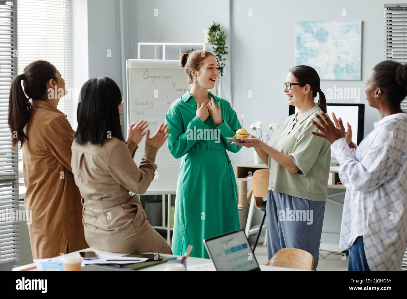 Group of employees congratulating their manager with birthday bringing ...