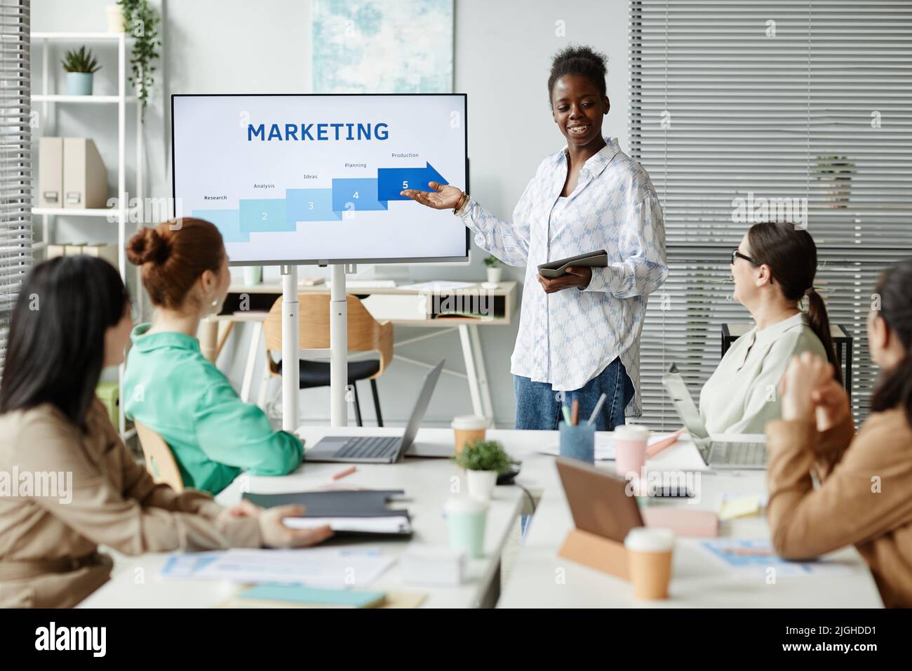 African young businesswoman pointing at monitor and presenting her ...
