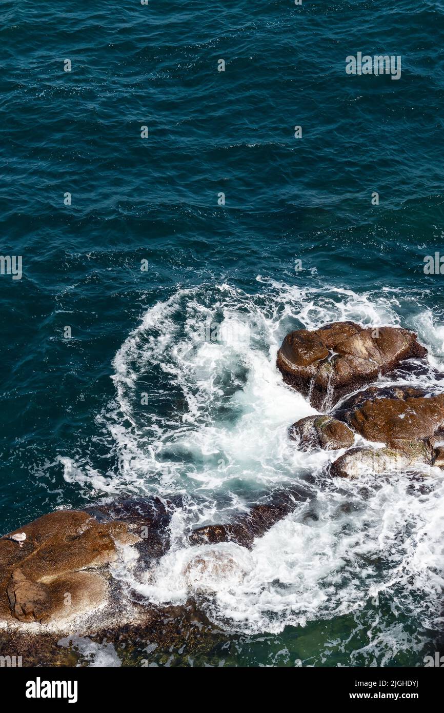 rocks in the sea. waves crashing the shore. water and stone texture ...