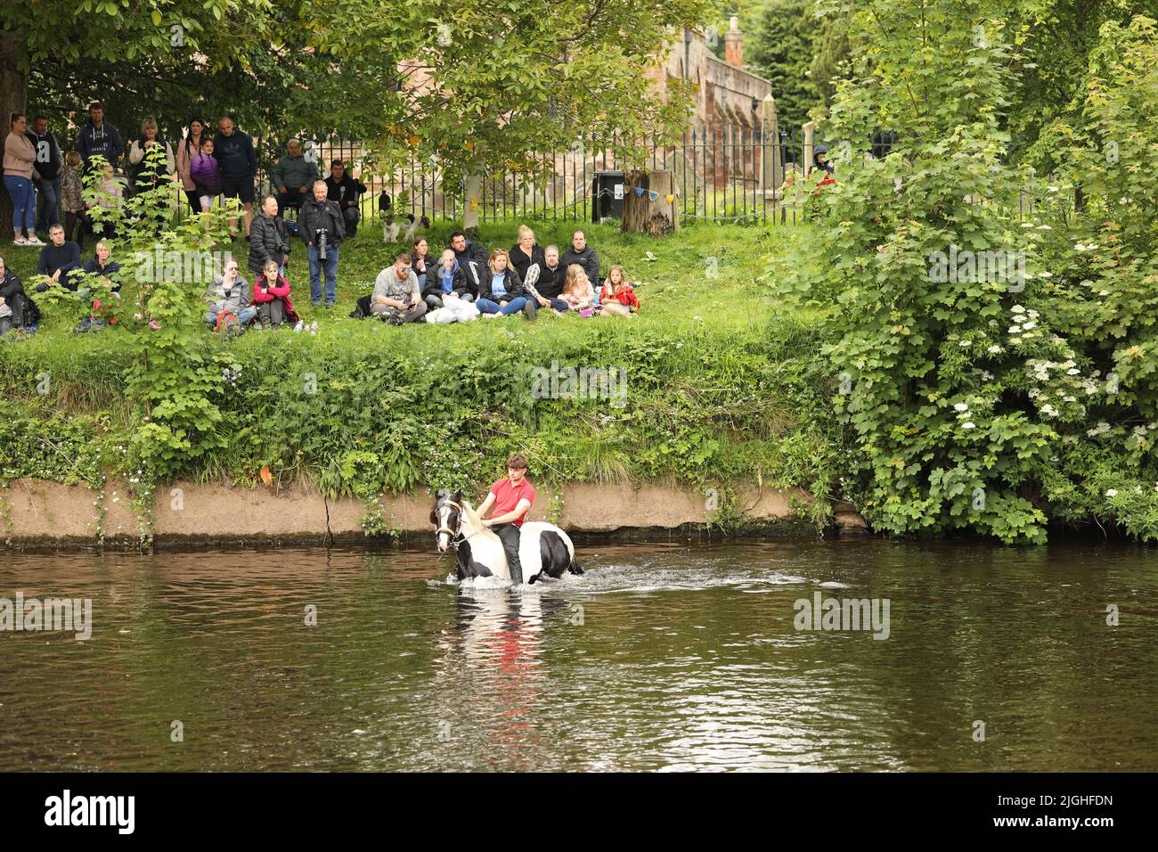 A young adult male riding his horse through the River Eden, Appleby ...