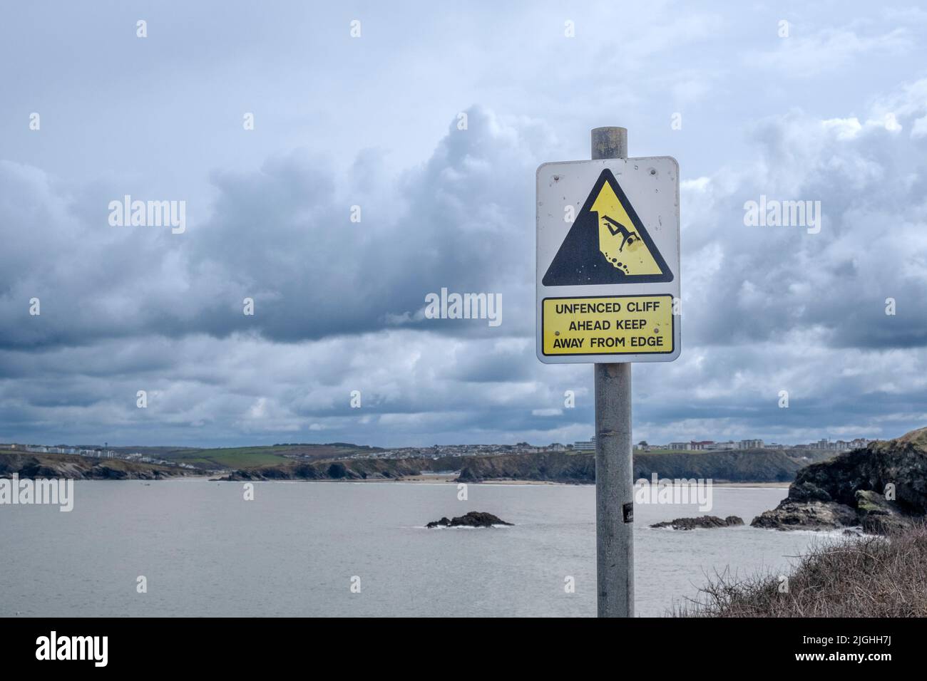 A warning sign on a cliff overlooking Newquay Bay in Cornwall in the UK ...