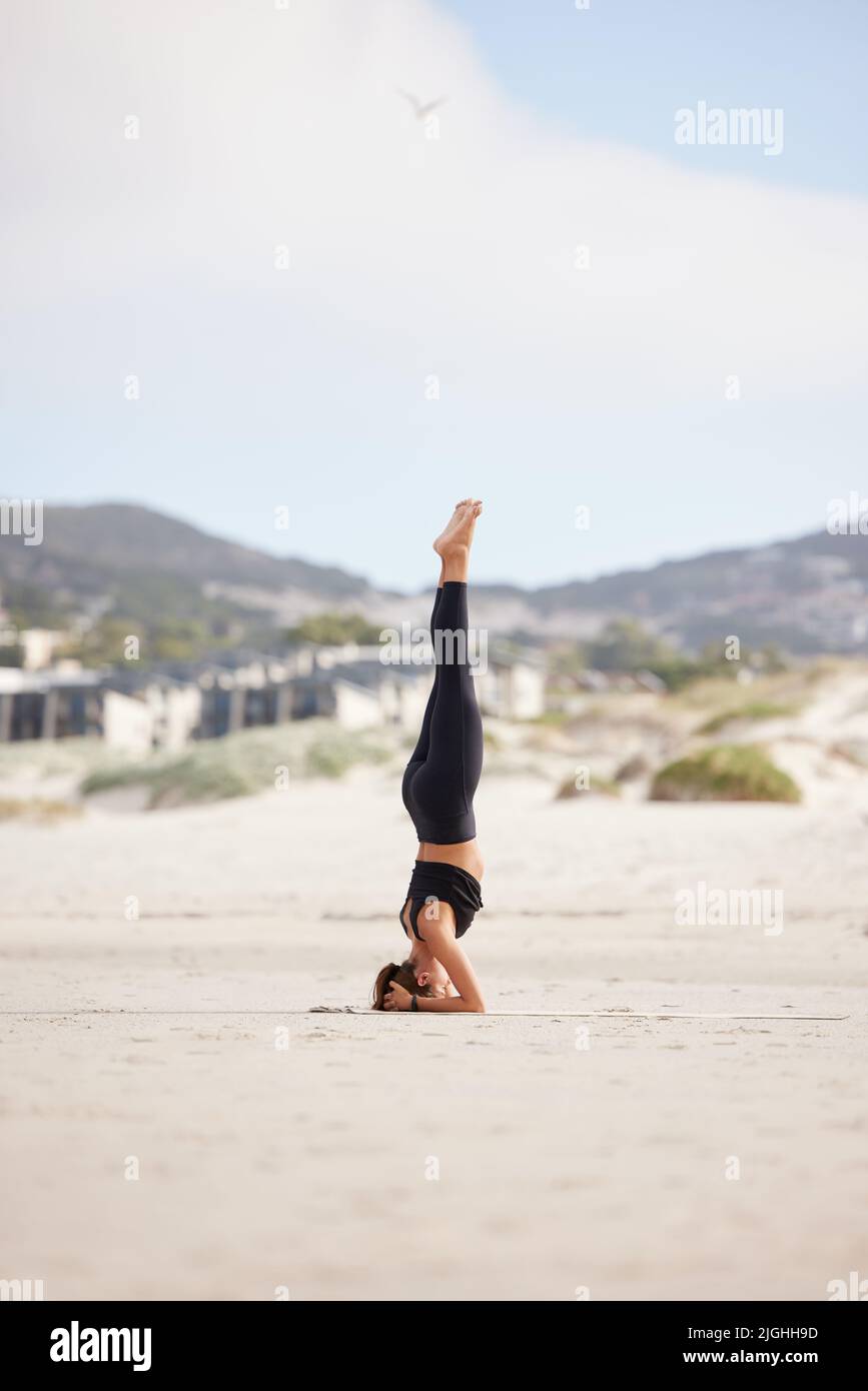 It takes patience to master this pose. a young woman doing a headstand ...