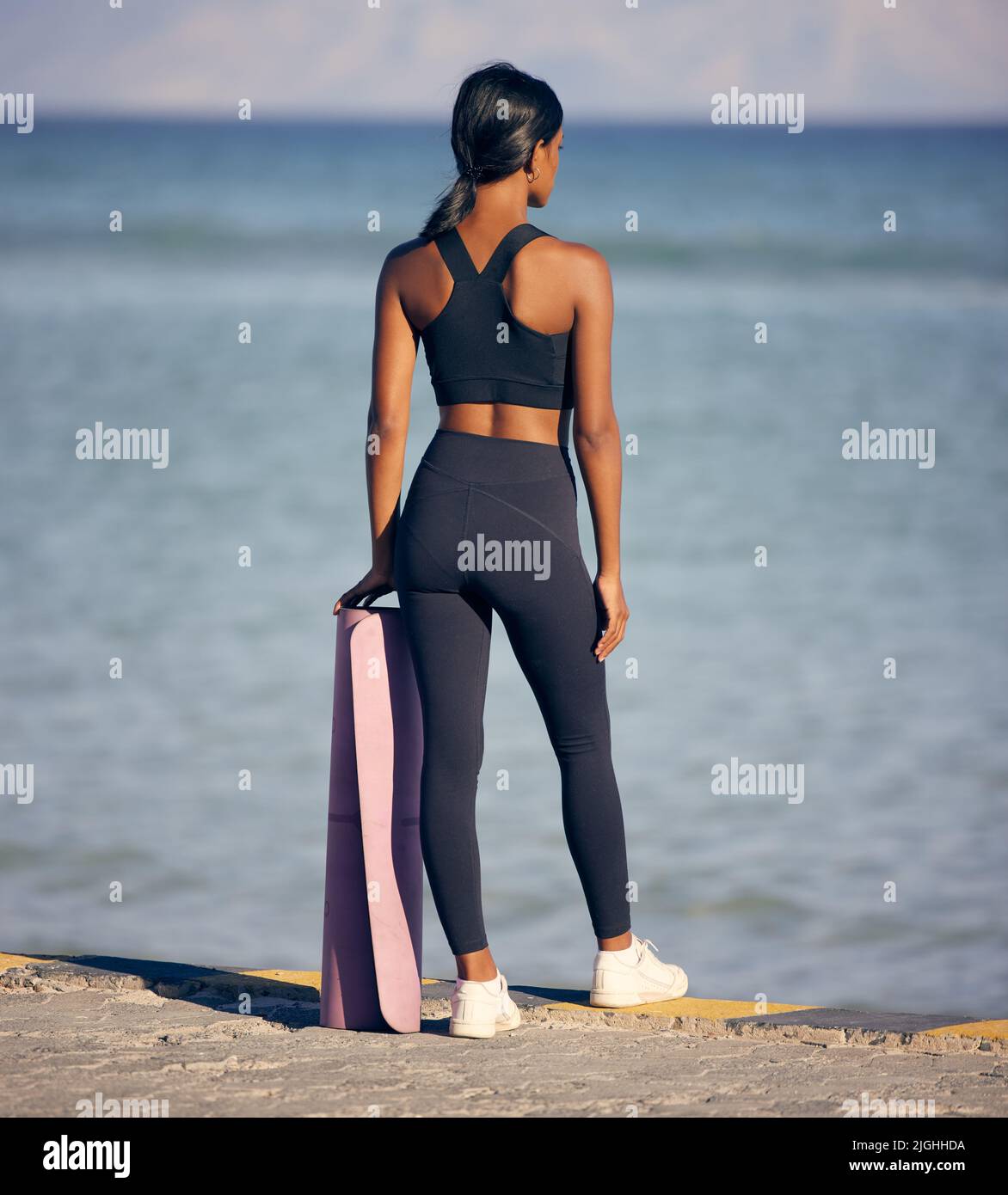 Yoga with a view. Rearview show of an attractive young woman standing ...