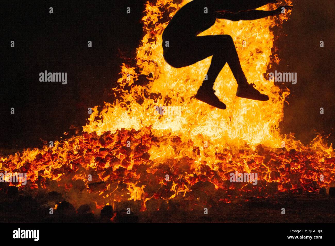 Summer solstice celebration jumping into the fire. Burning flames ...