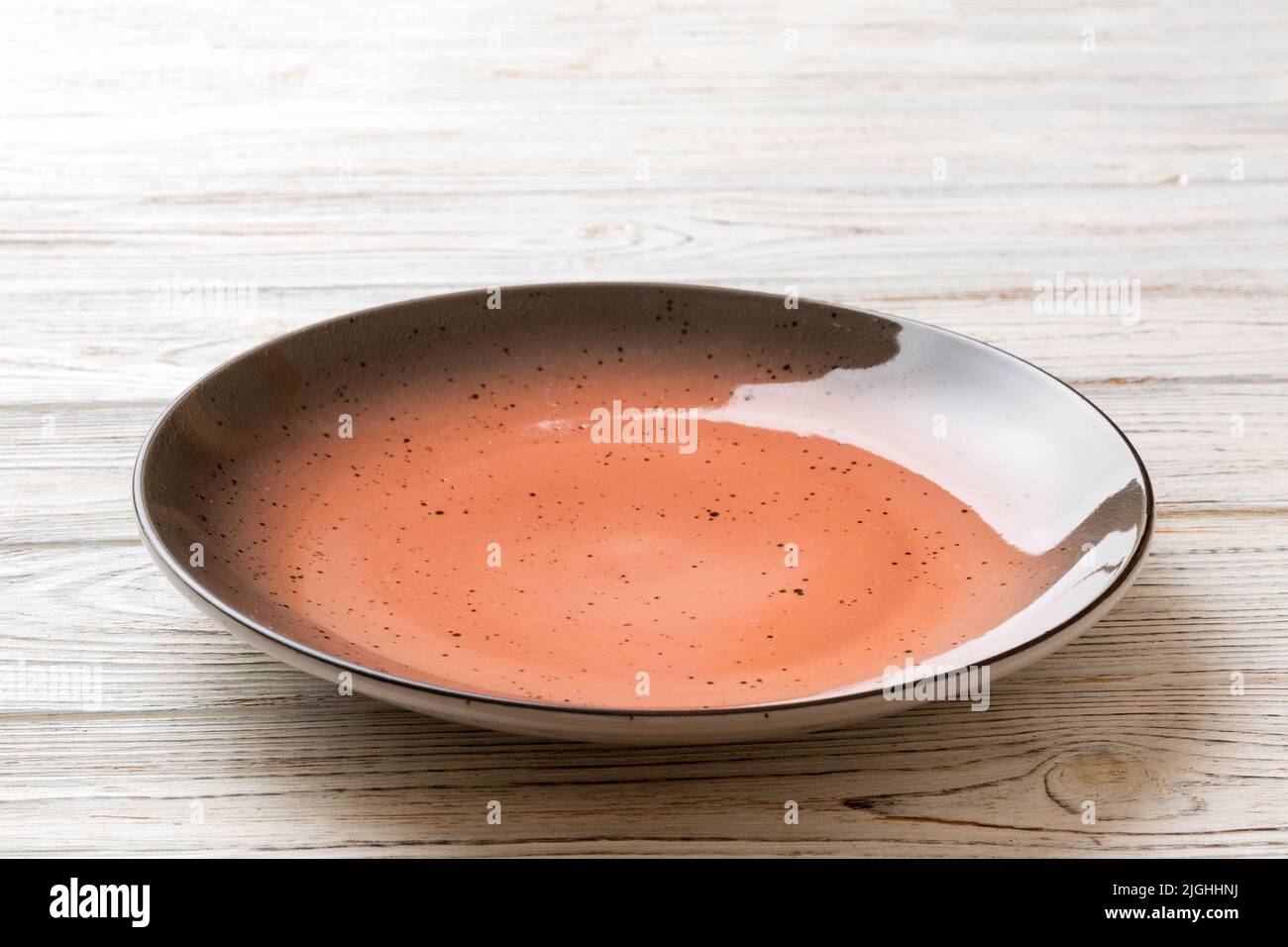 Perspective view of empty red plate on wooden background. Empty space ...