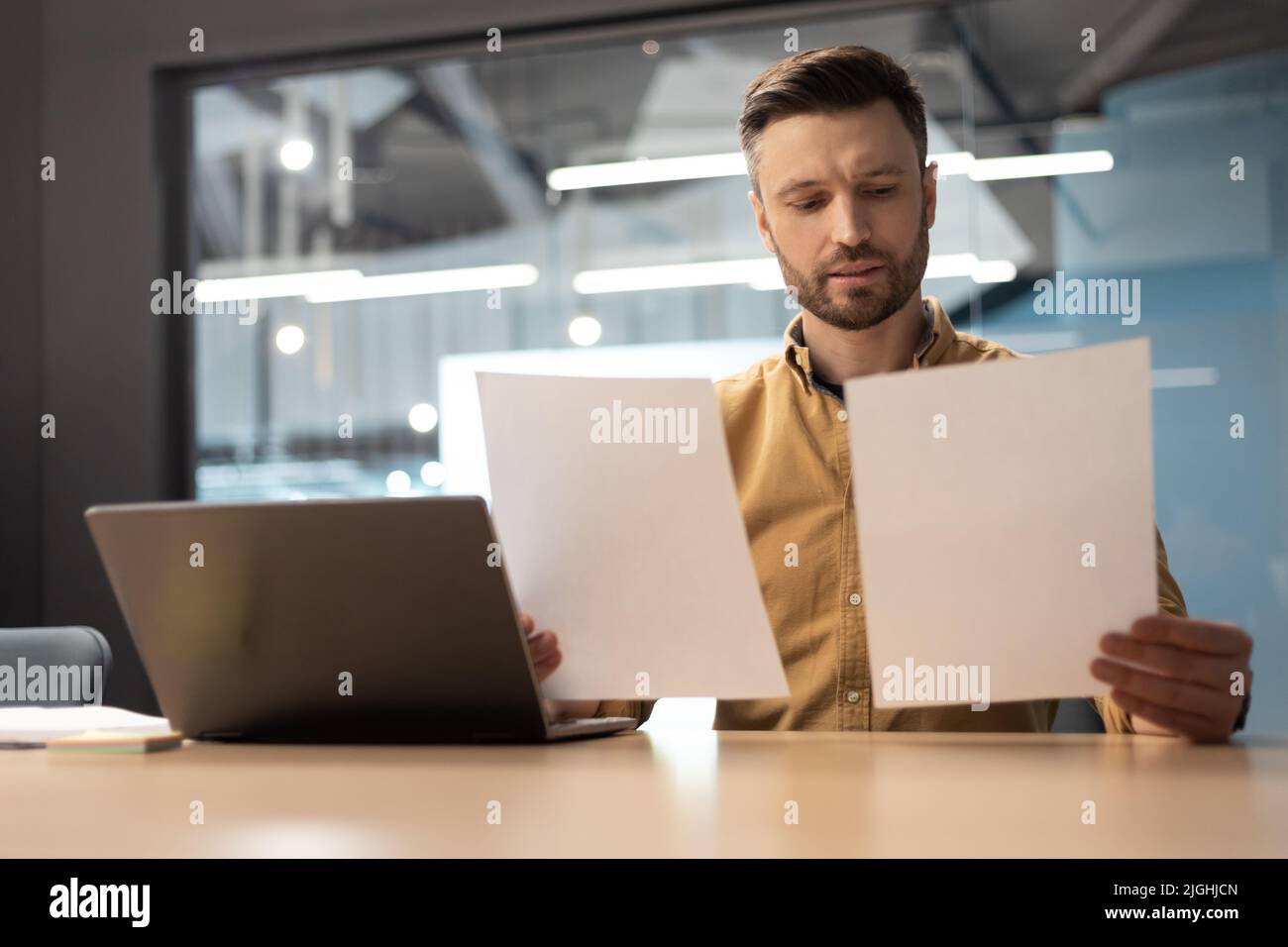 Young man doing paperwork at office desk hi-res stock photography and ...
