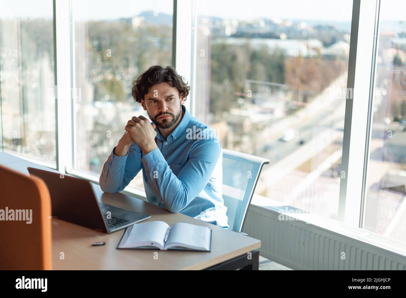 Thoughtful middle aged male manager working on laptop computer in ...