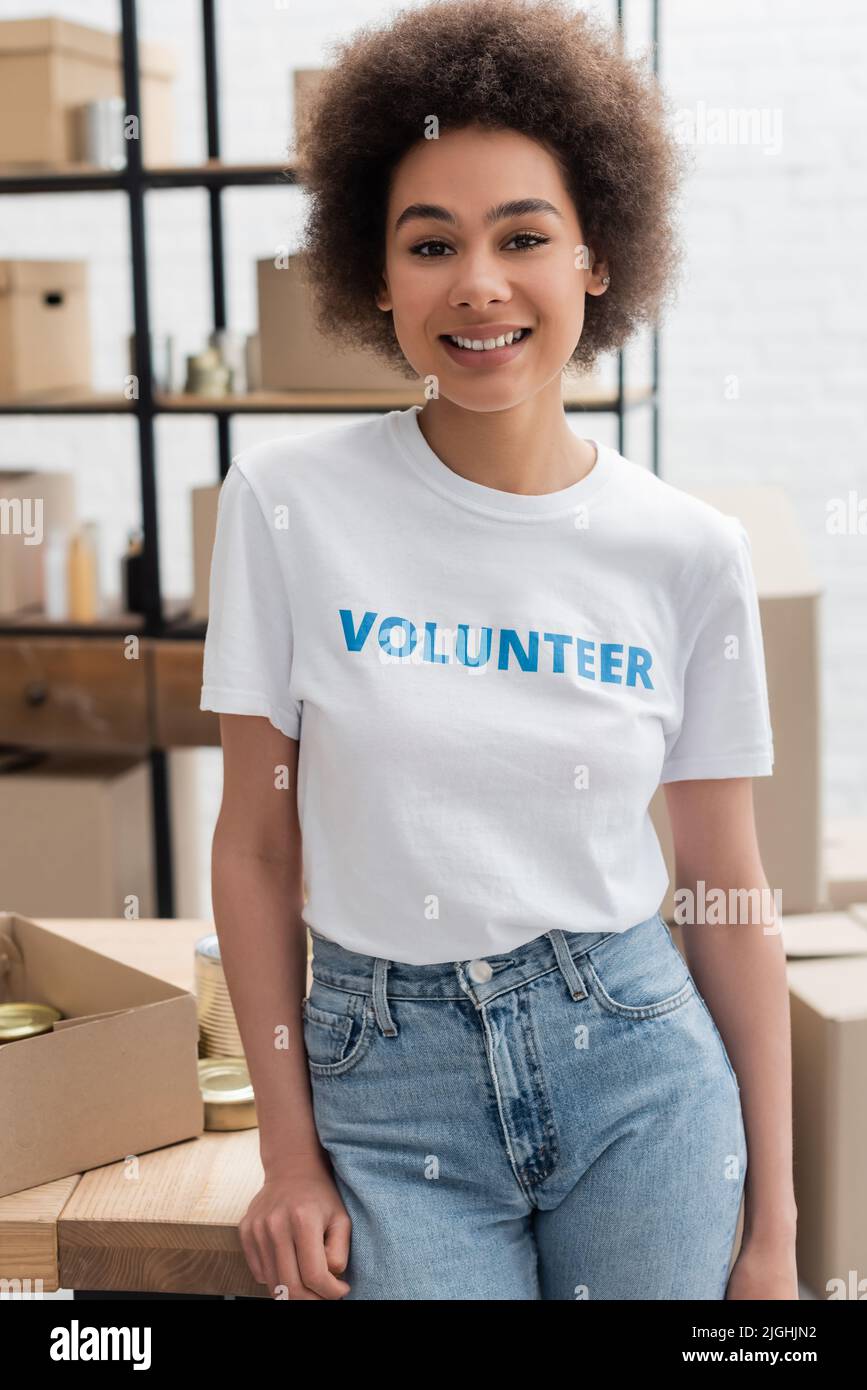 happy african american woman in t-shirt with volunteer lettering ...
