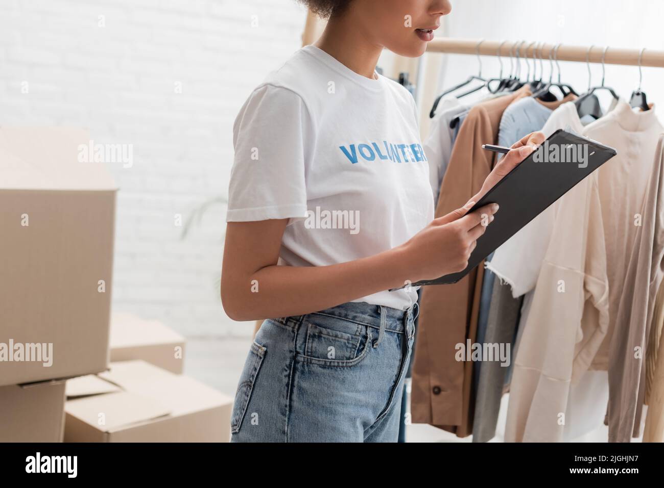 cropped view of african american volunteer writing on clipboard near ...