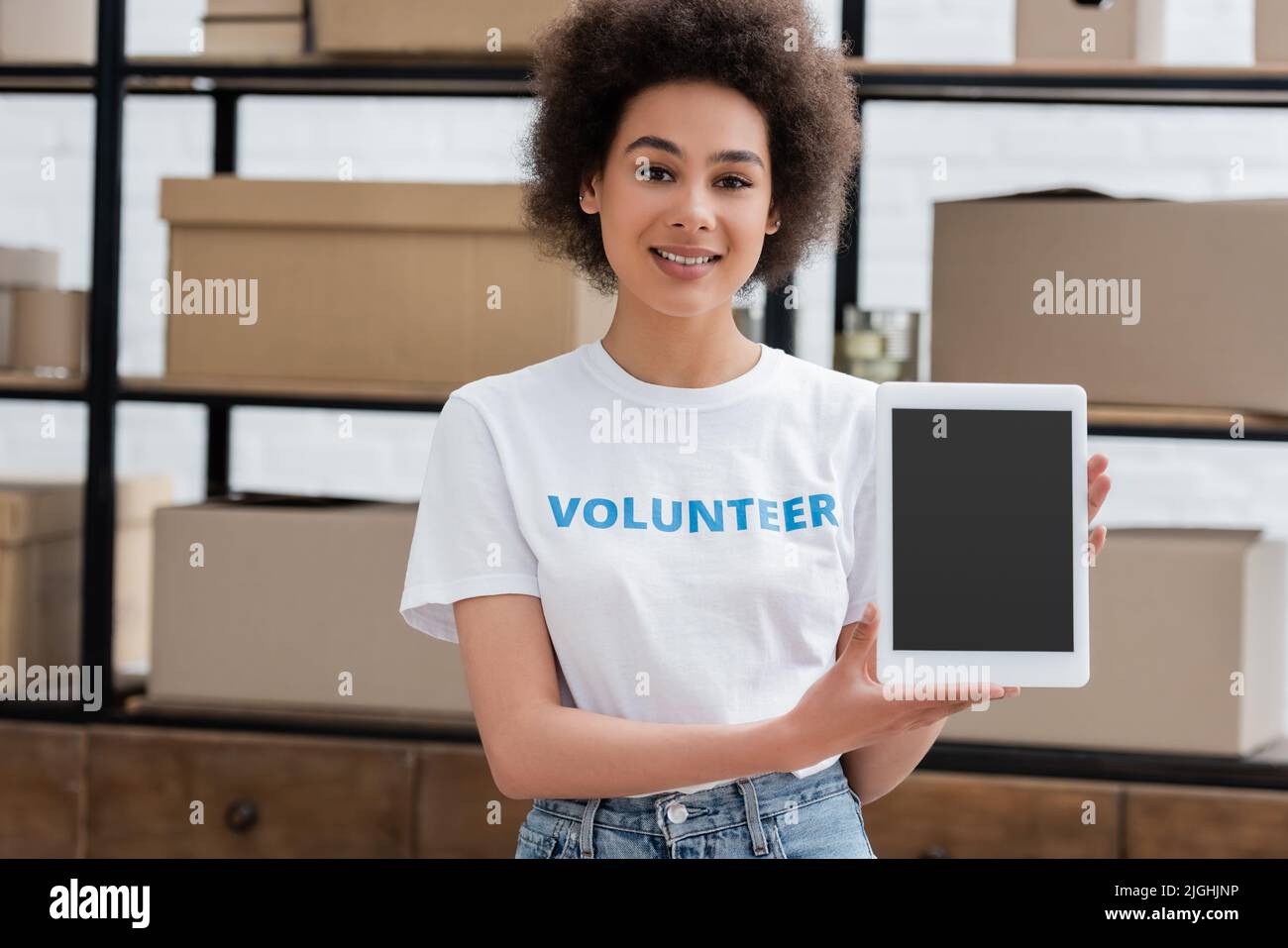 happy african american volunteer holding digital tablet with blank ...