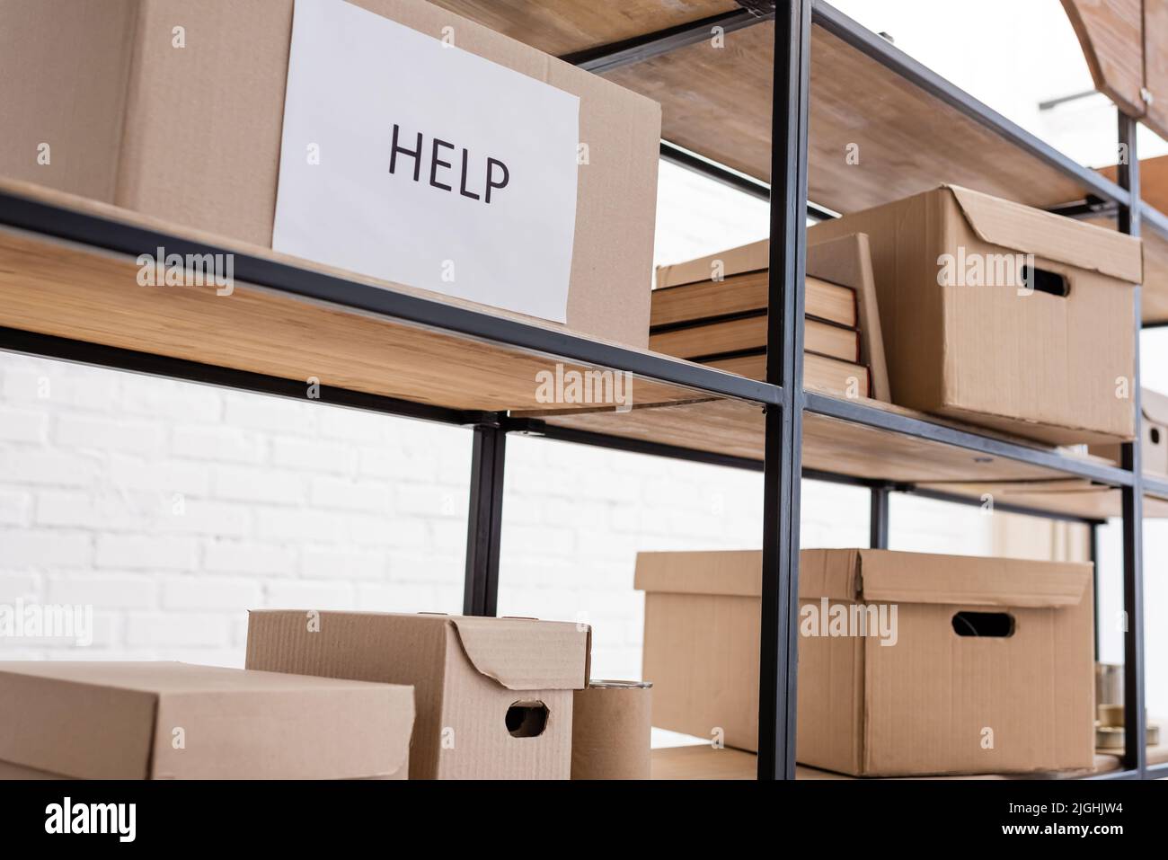 carton box with help lettering on rack in charity warehouse Stock Photo ...