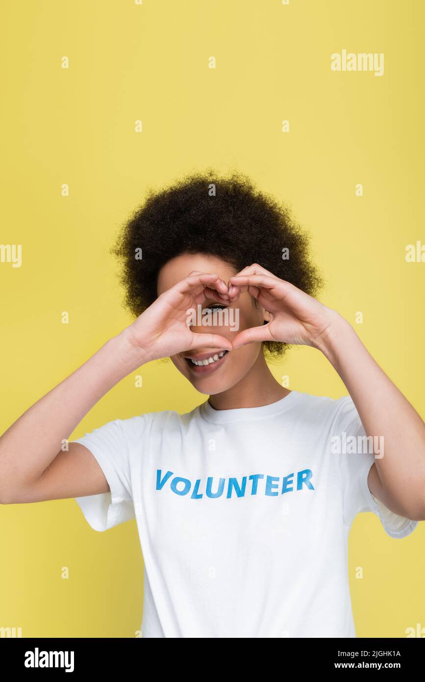 cheerful african american volunteer showing heart sign near face ...