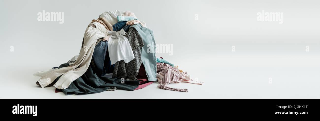 mess of different clothes on grey background with copy space, banner ...