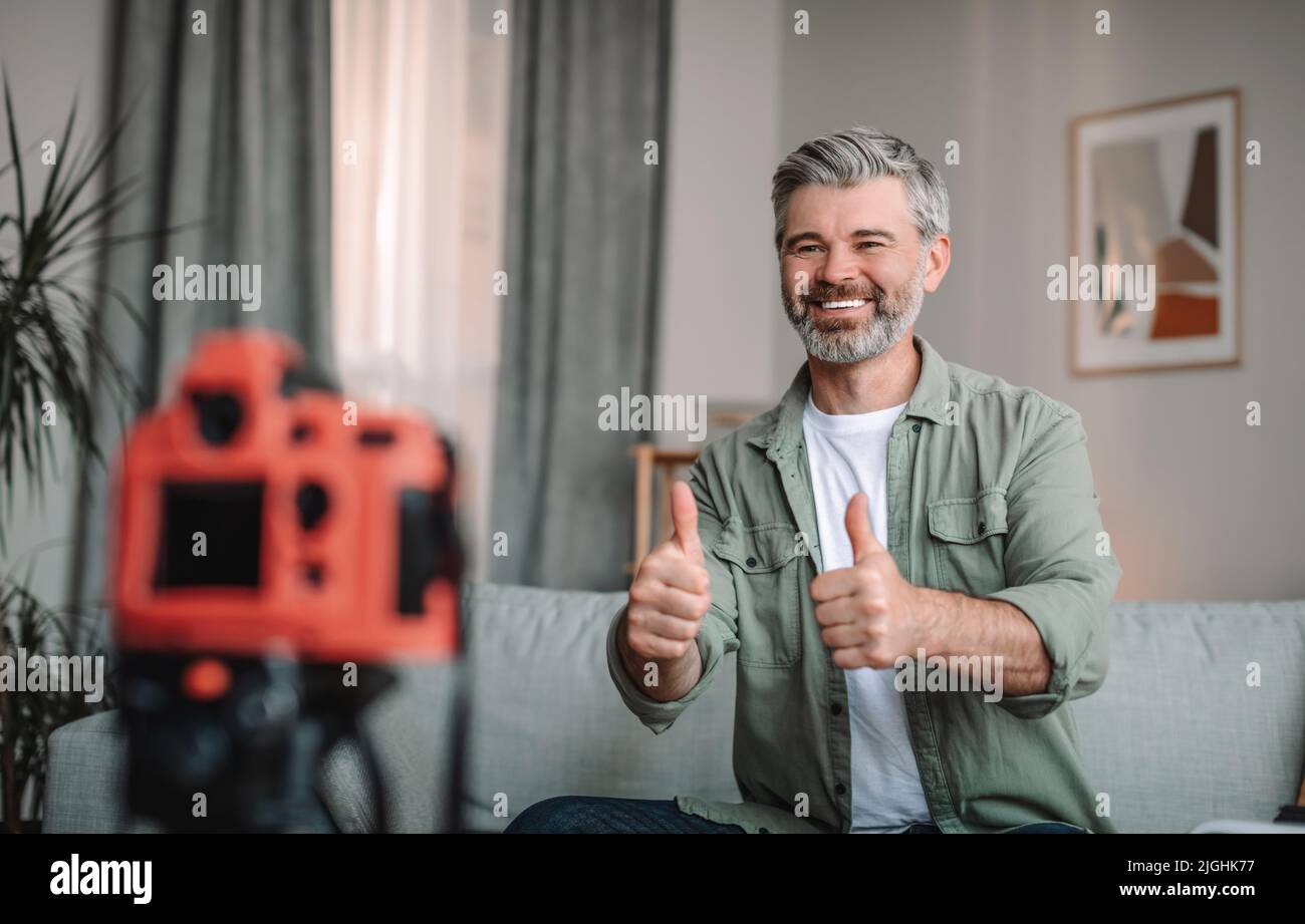 Glad happy caucasian old male blogger with beard showing thumbs up and ...