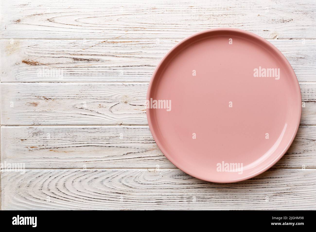 Top view of empty pink plate on wooden background. Empty space for your ...