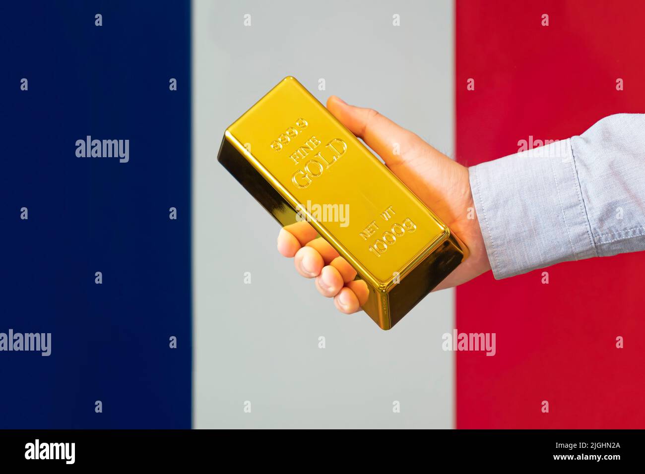 The gold reserve of the France concept. Gold bar in hand on French flag ...