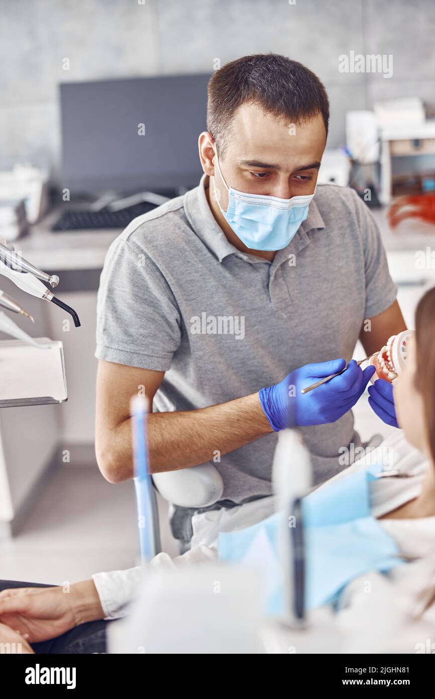 Professional doctor is choosing a colour of teeth in modern dental ...